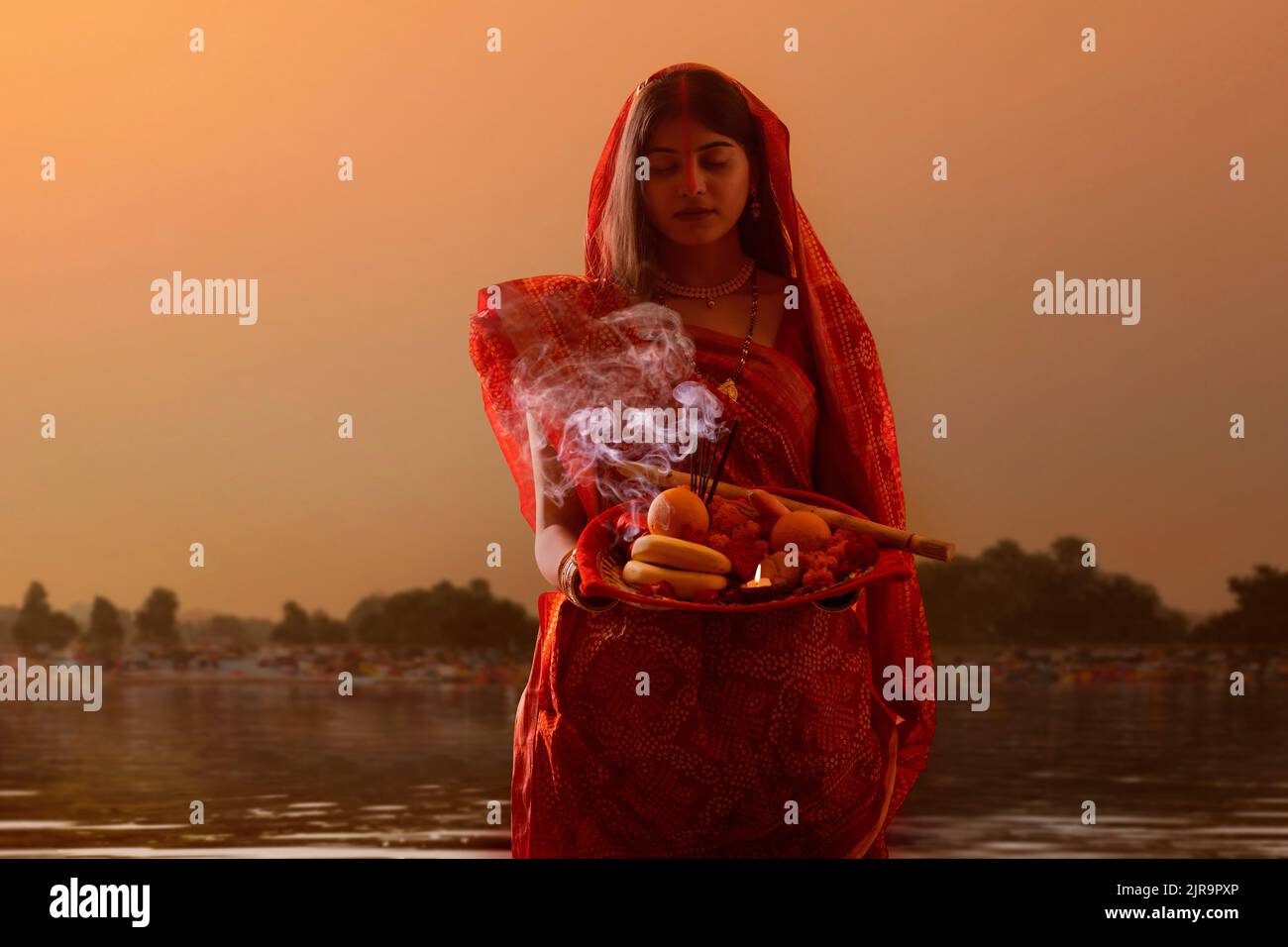 woman from Bihar offers prayers to the sun in the early morning hours ...