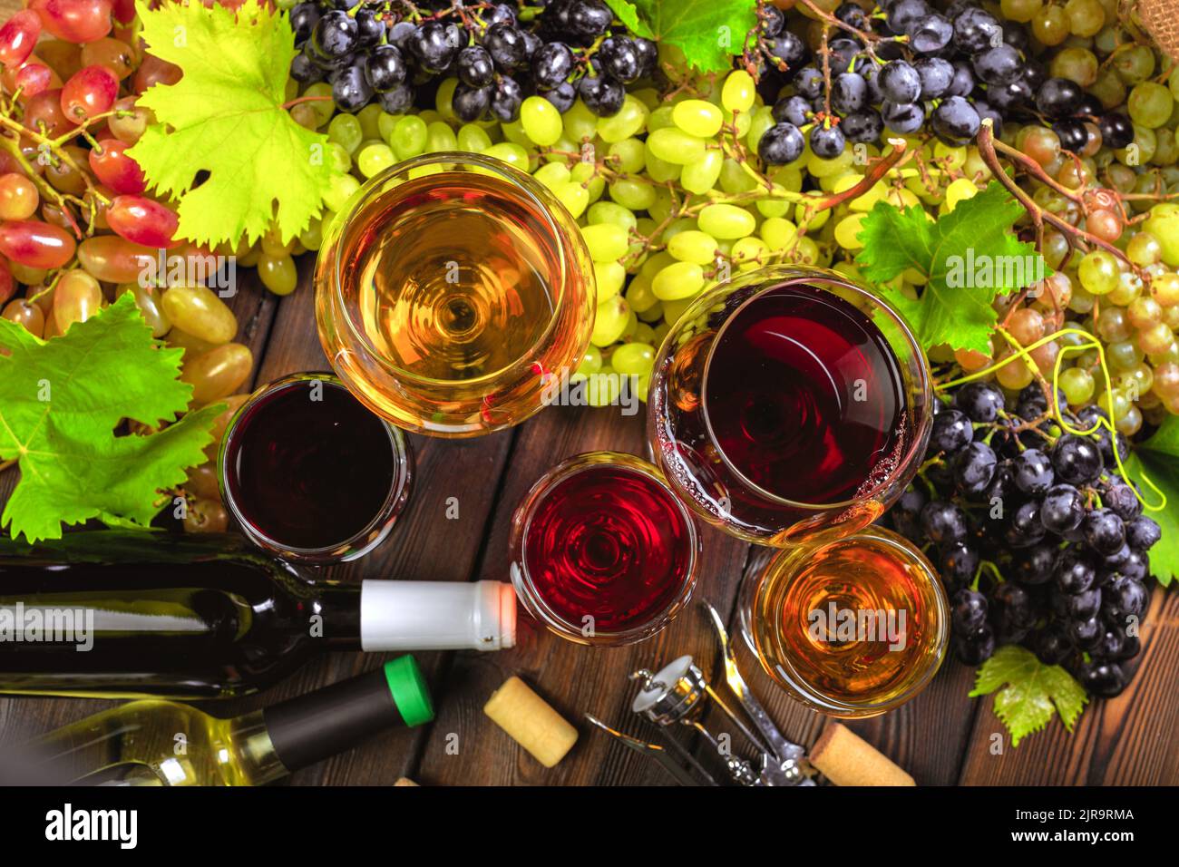 wine with branches of white grapes. On a wooden table Stock Photo - Alamy