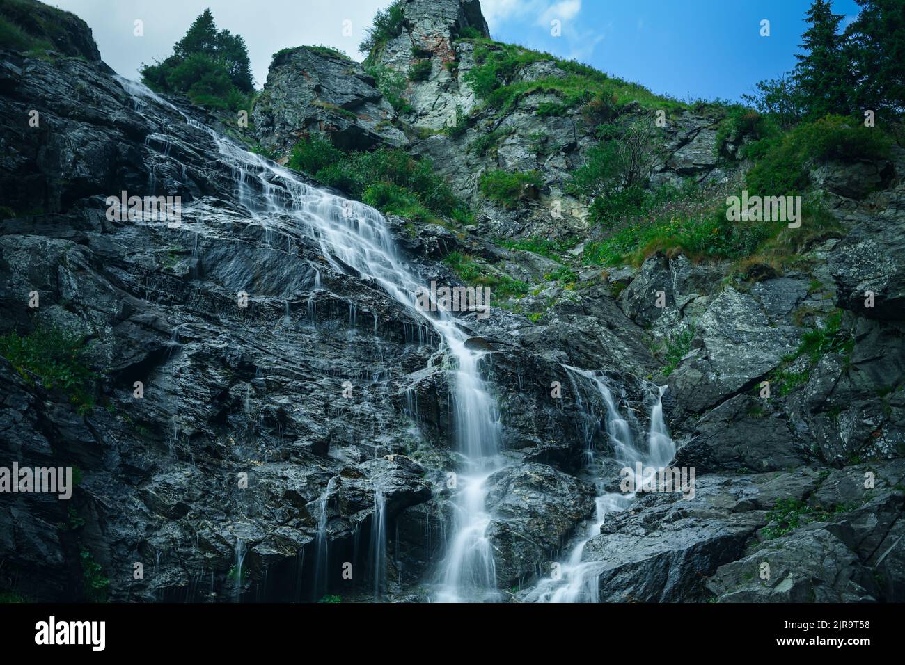 A waterfall flowing over huge rocks Stock Photo - Alamy