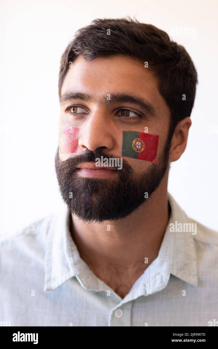 Vertical image of serious multiracial man with flags of portugal on ...