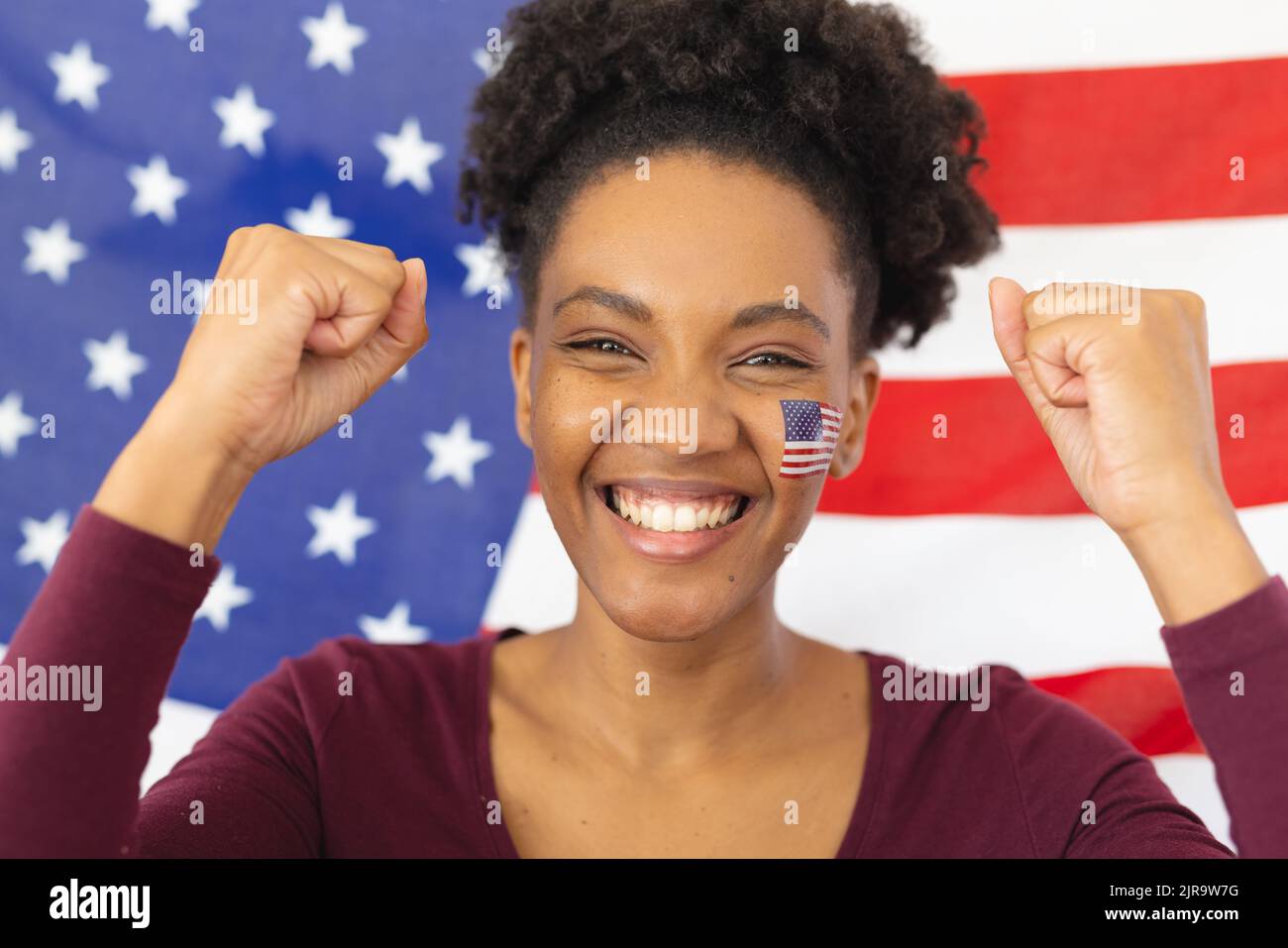 Image of happy african american woman with flags of usa on face over ...