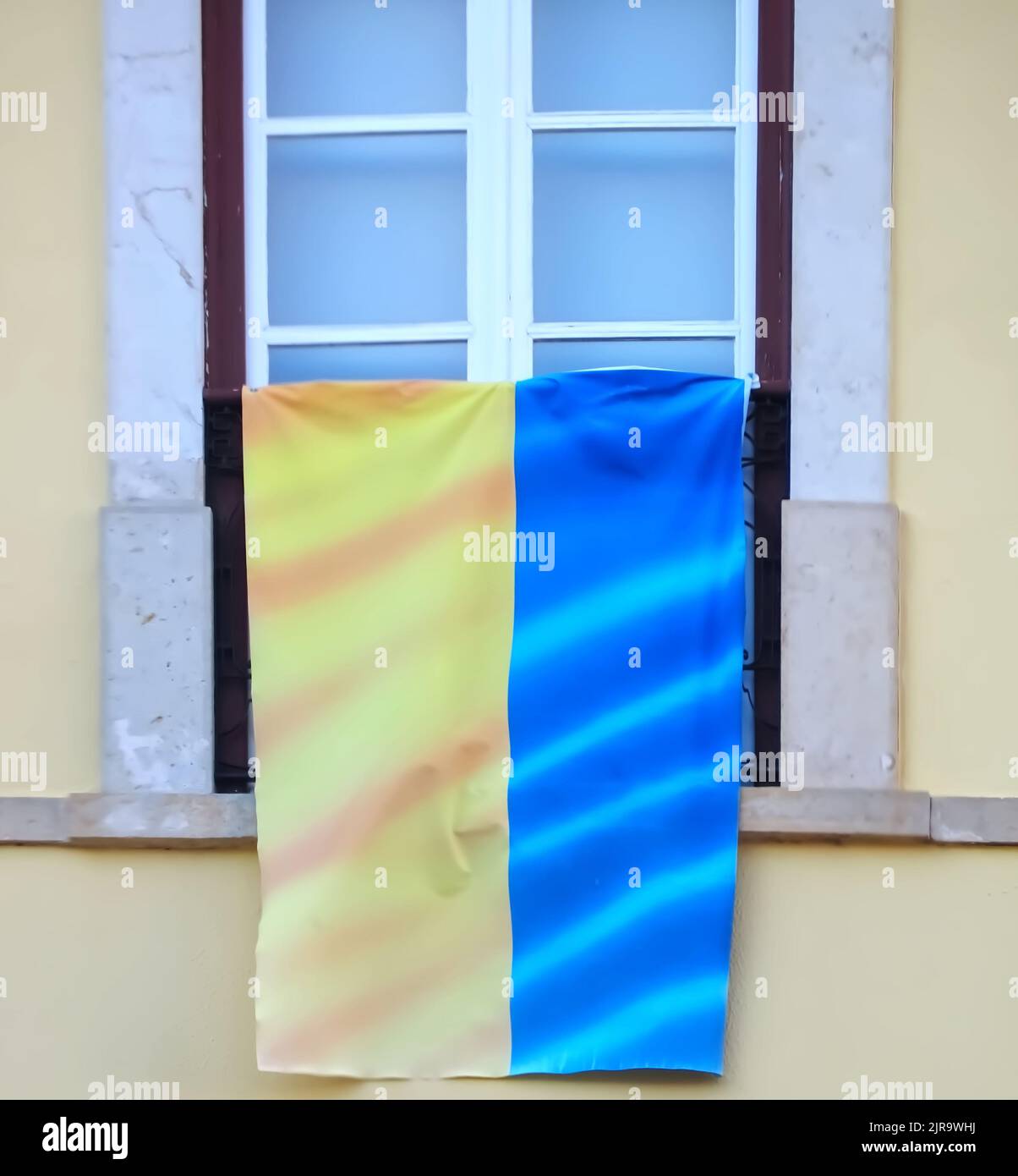 Ukrainian flag hangs on a window to show solidarity Stock Photo - Alamy