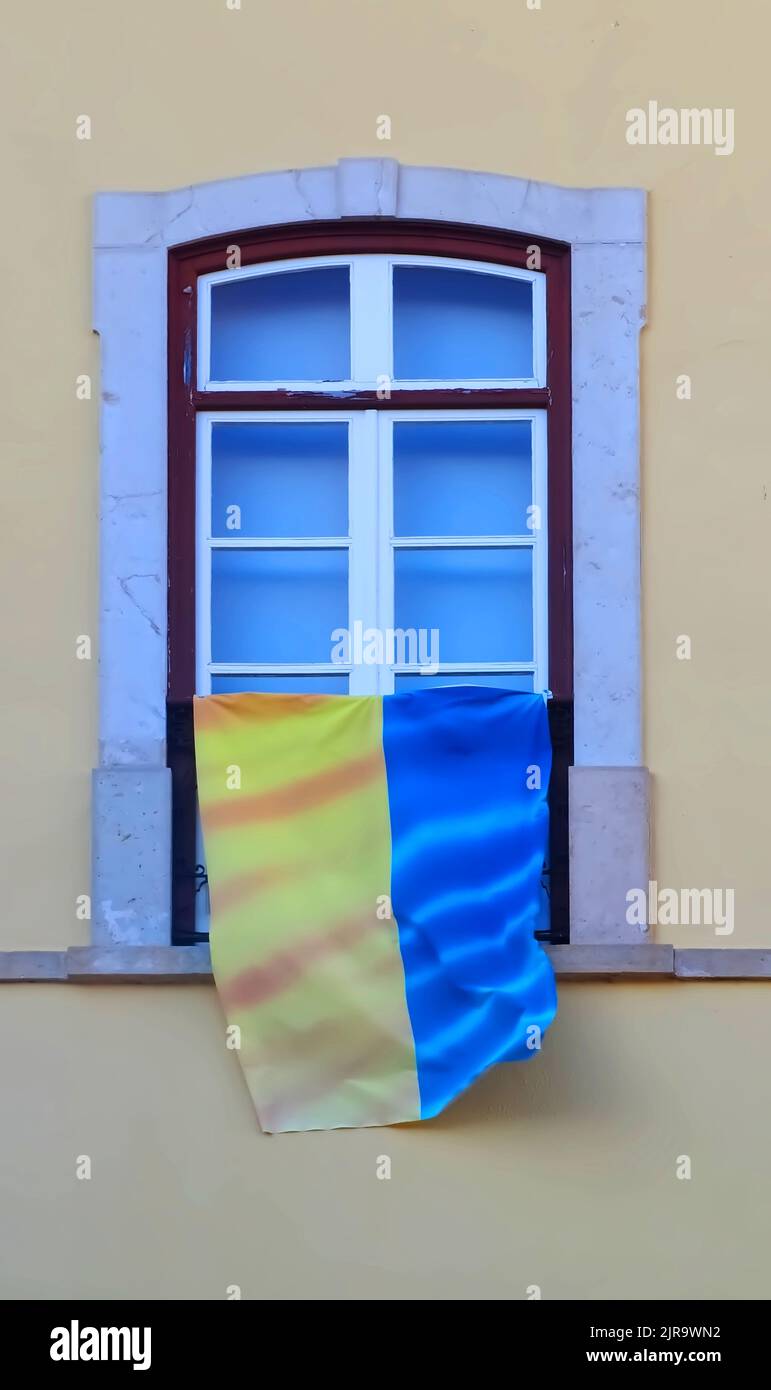 Ukrainian flag hangs on a window to show solidarity Stock Photo - Alamy
