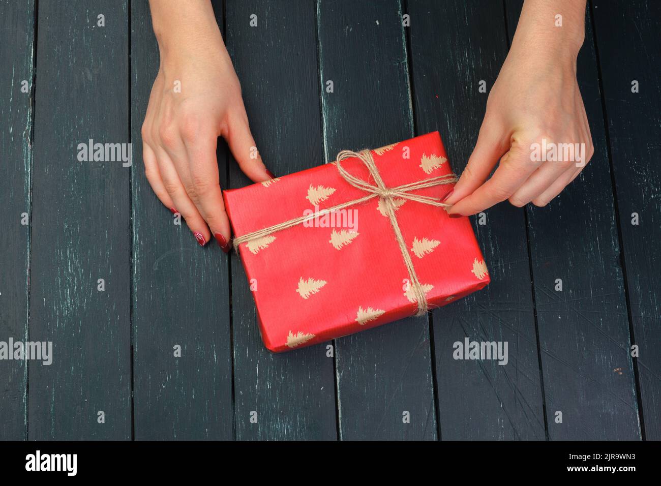 gift box in hand girls on wood table Stock Photo - Alamy
