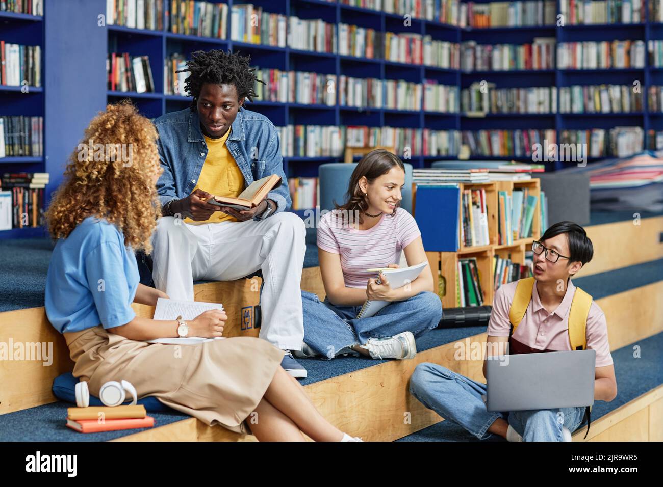 Diverse group of students in library lounge with vibrant blue colors ...
