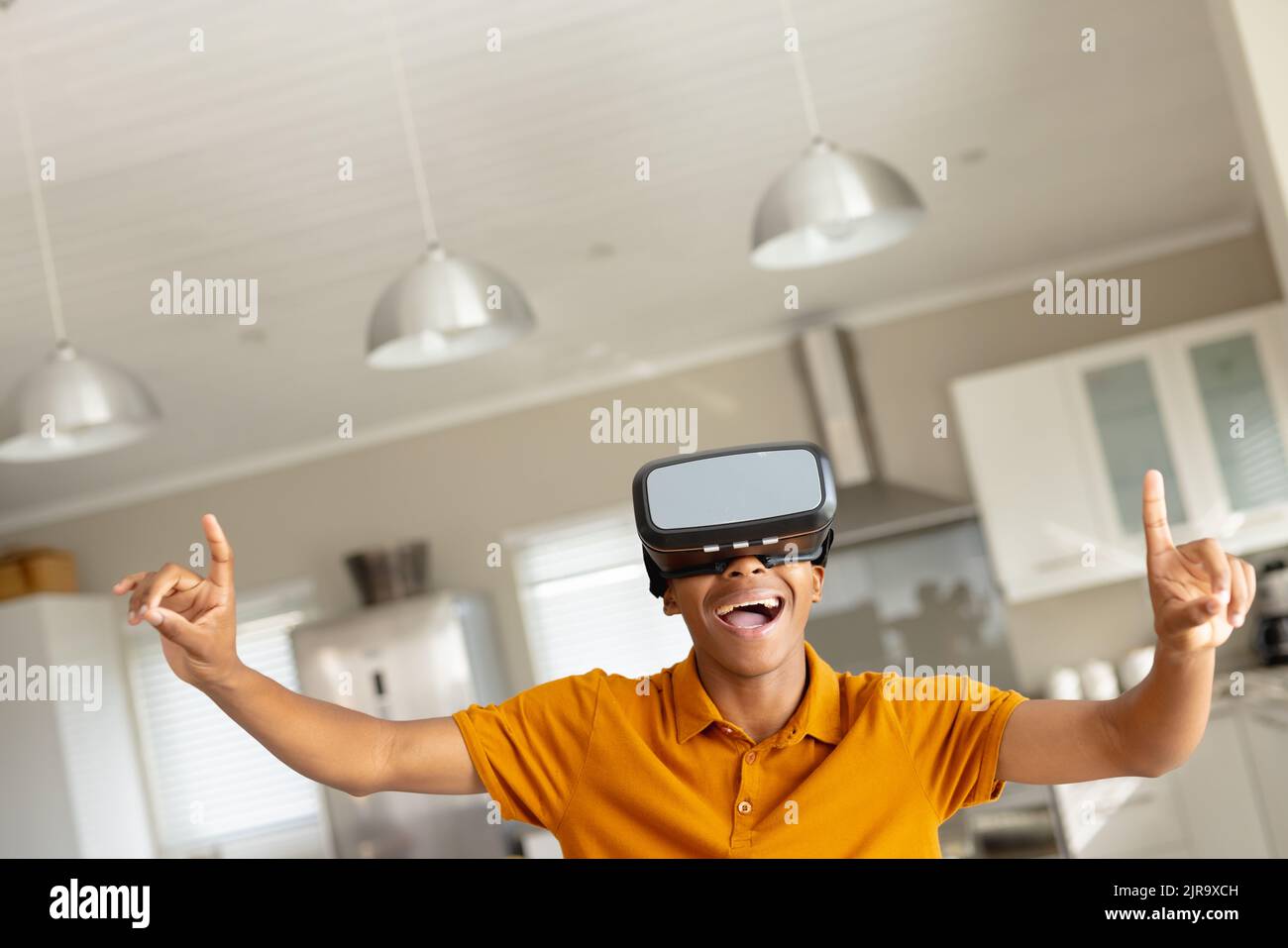 Happy african american male teenager in kitchen using vr headset Stock ...