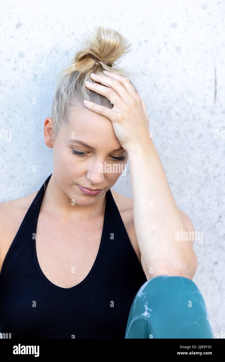 Caucasian blonde young sport Woman with hand on her head getting ...