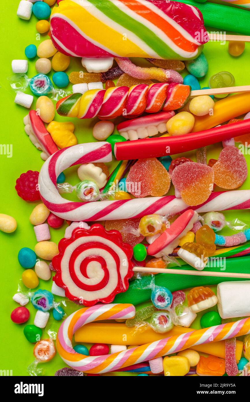 Colorful candies on green background Stock Photo - Alamy