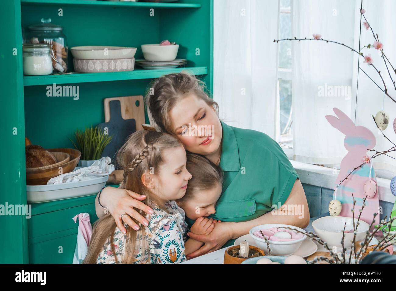 Girls, sisters, mother at table with Easter decoration. Celebration in ...