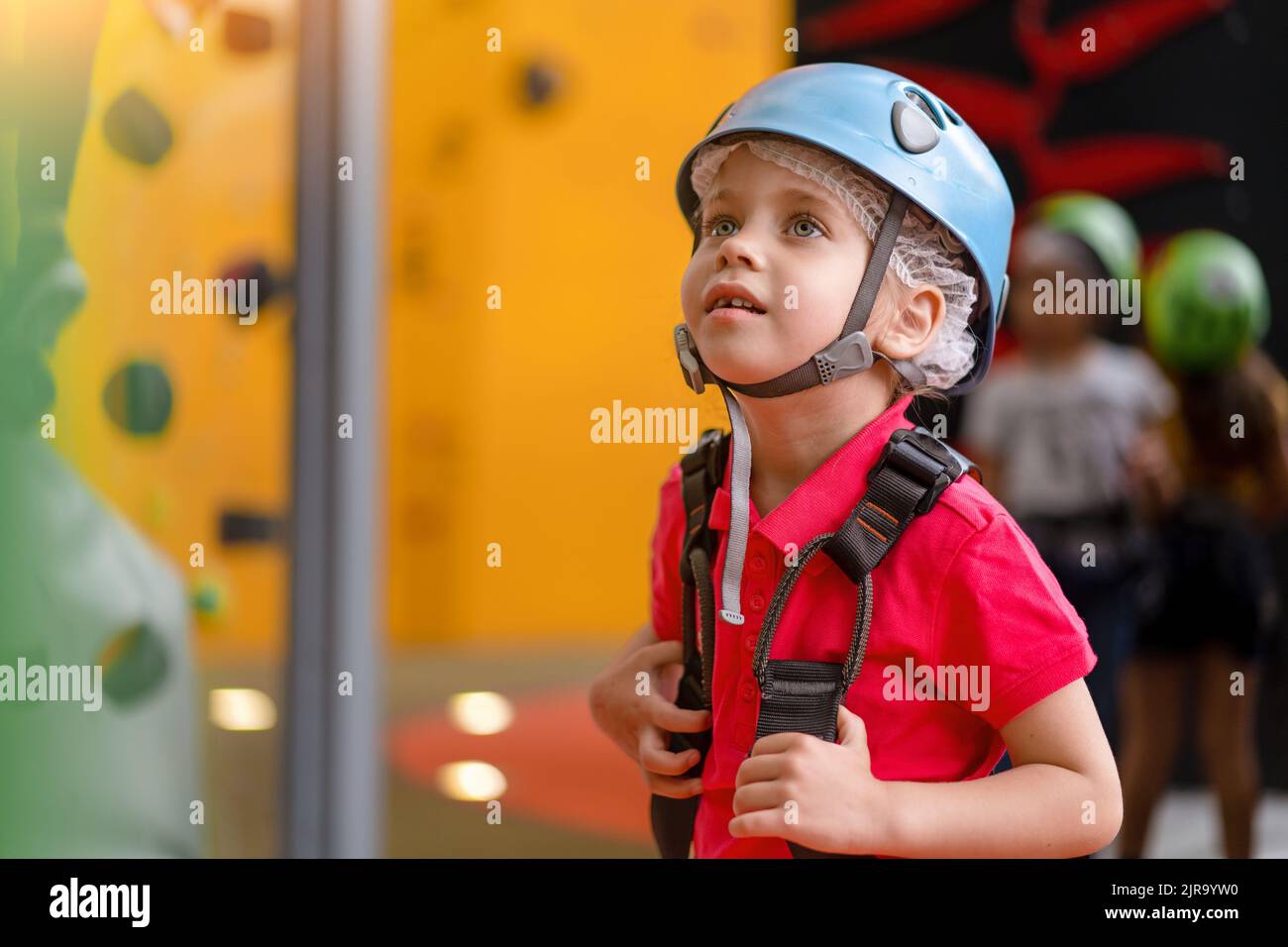 Cute little girl climber in blue protective helmet and gear for ...