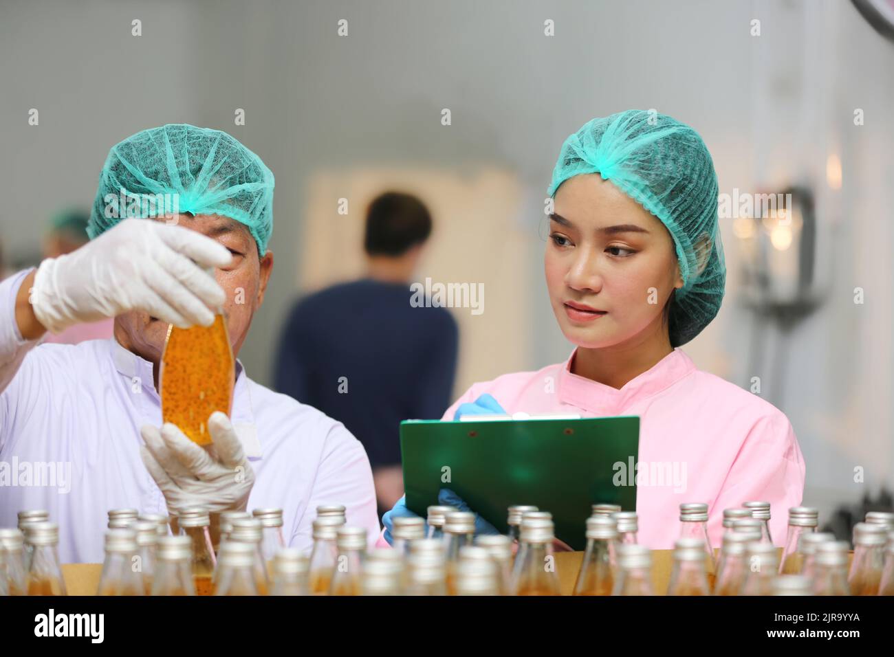 worker controlling the work of machine in production line at beverage ...