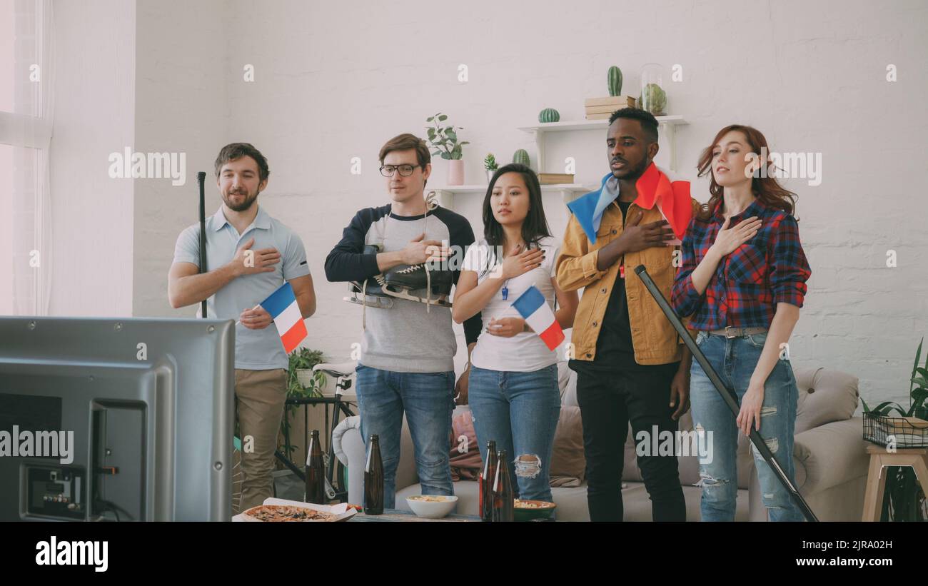 Multi ethnic group of friends sport fans listening and singing French ...