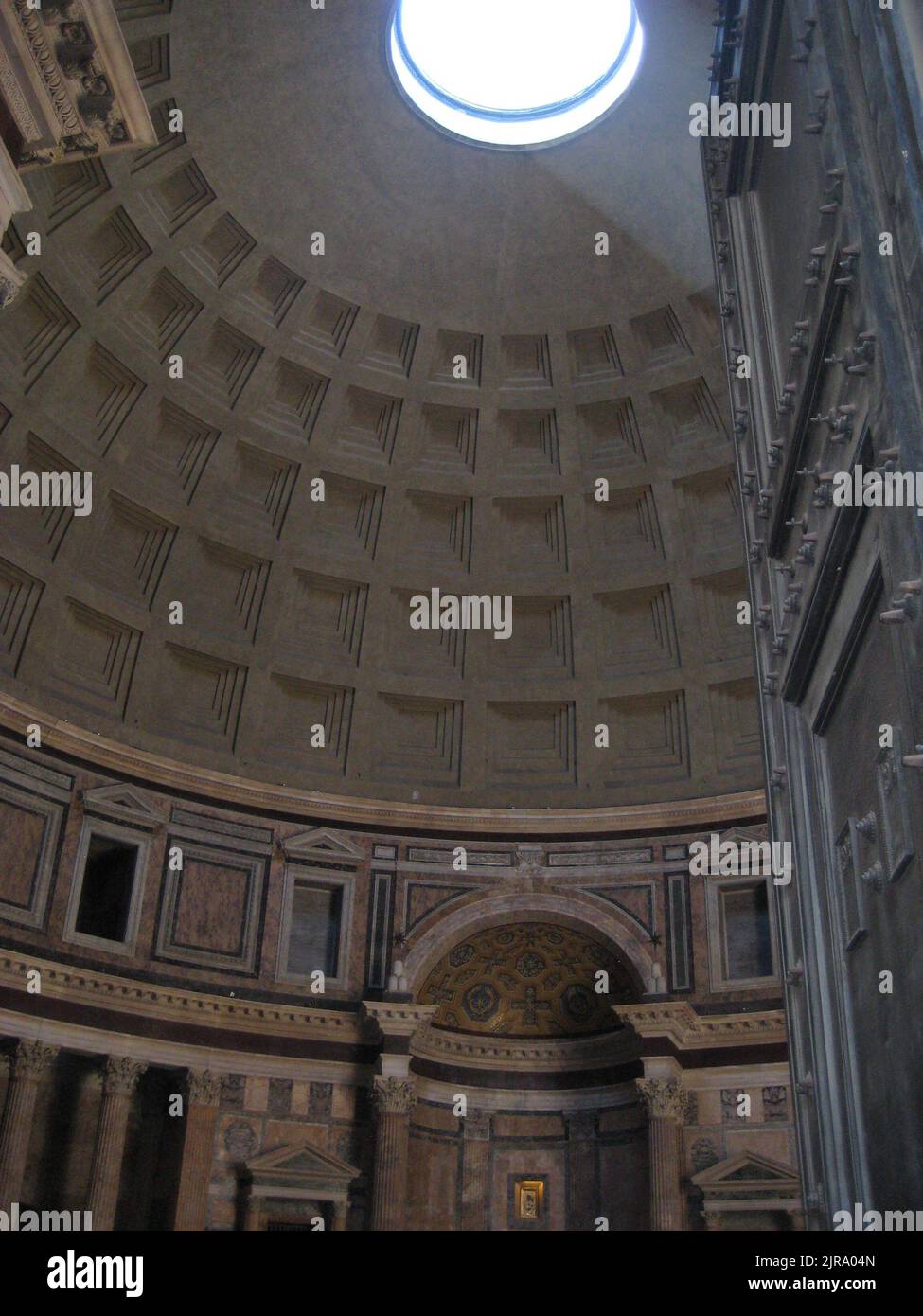 A vertical inside view of a pantheon in Rome with light coming from the ...