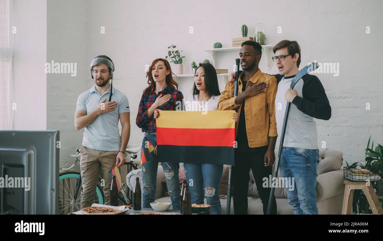 Multi ethnic group of friends sport fans listening and singing German ...