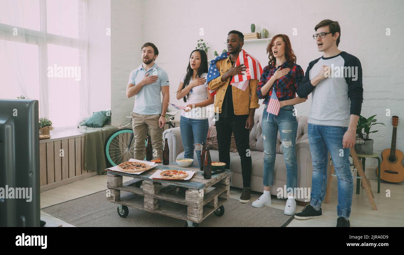 Multi ethnic group of friends sport fans singing national USA anthem ...