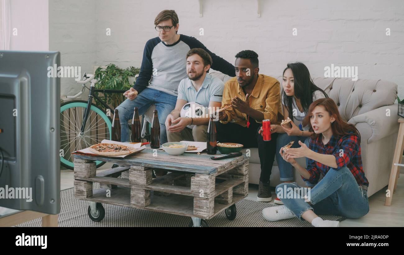 Multi-ethnic group of friends sports fans watching football ...