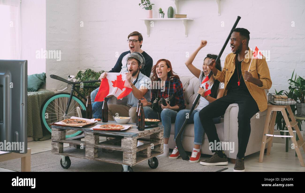 Multi ethnic group of friends sports fans with Canadian national flags ...