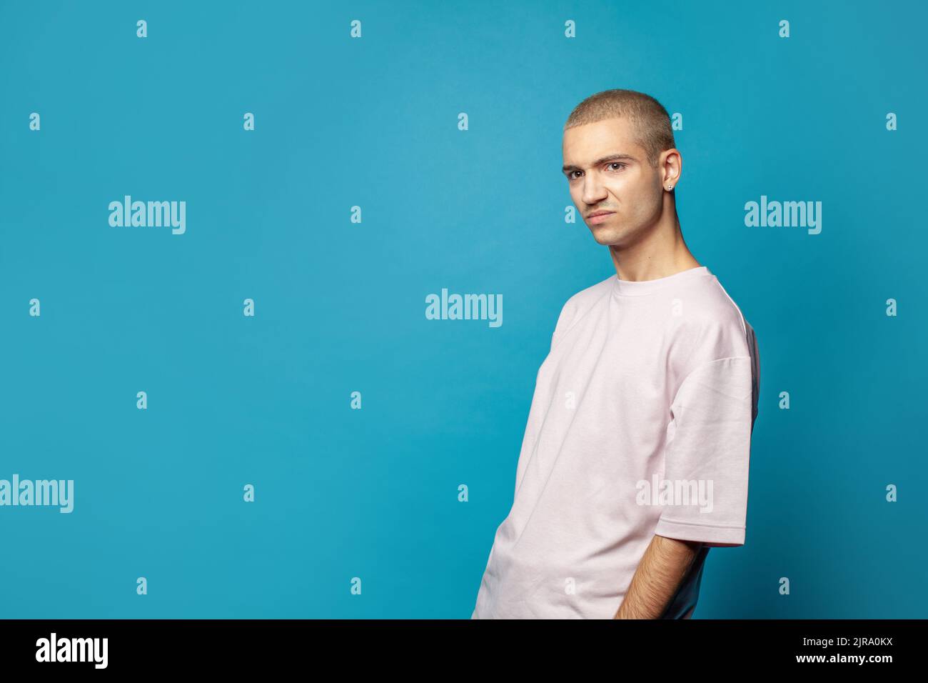 Sad unhappy young man standing on bright blue background Stock Photo ...