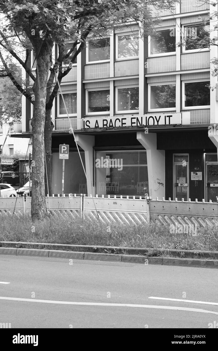 A vertical black and white shot of an 80s building with tile facade ...