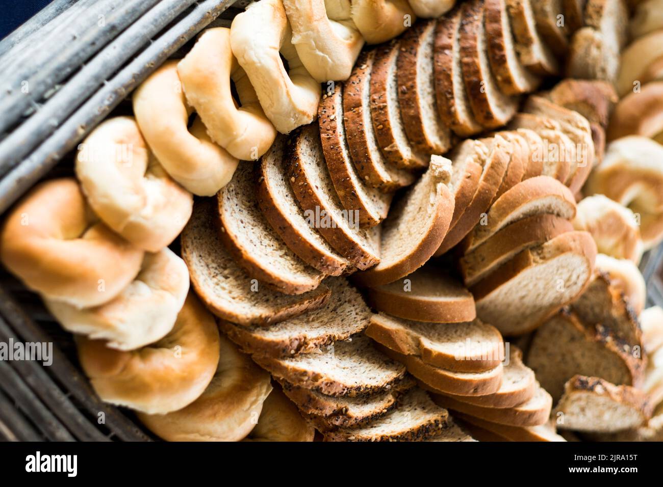 A top view of variety of bread slices and bagels on fourchette table ...