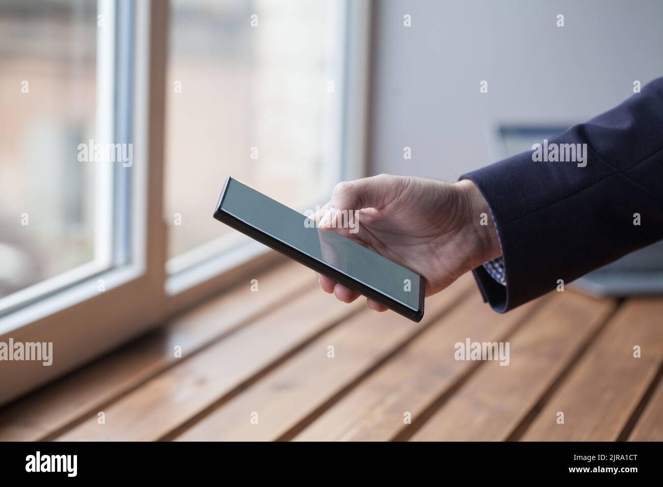 Businessman using smart phone in office space background close up ...