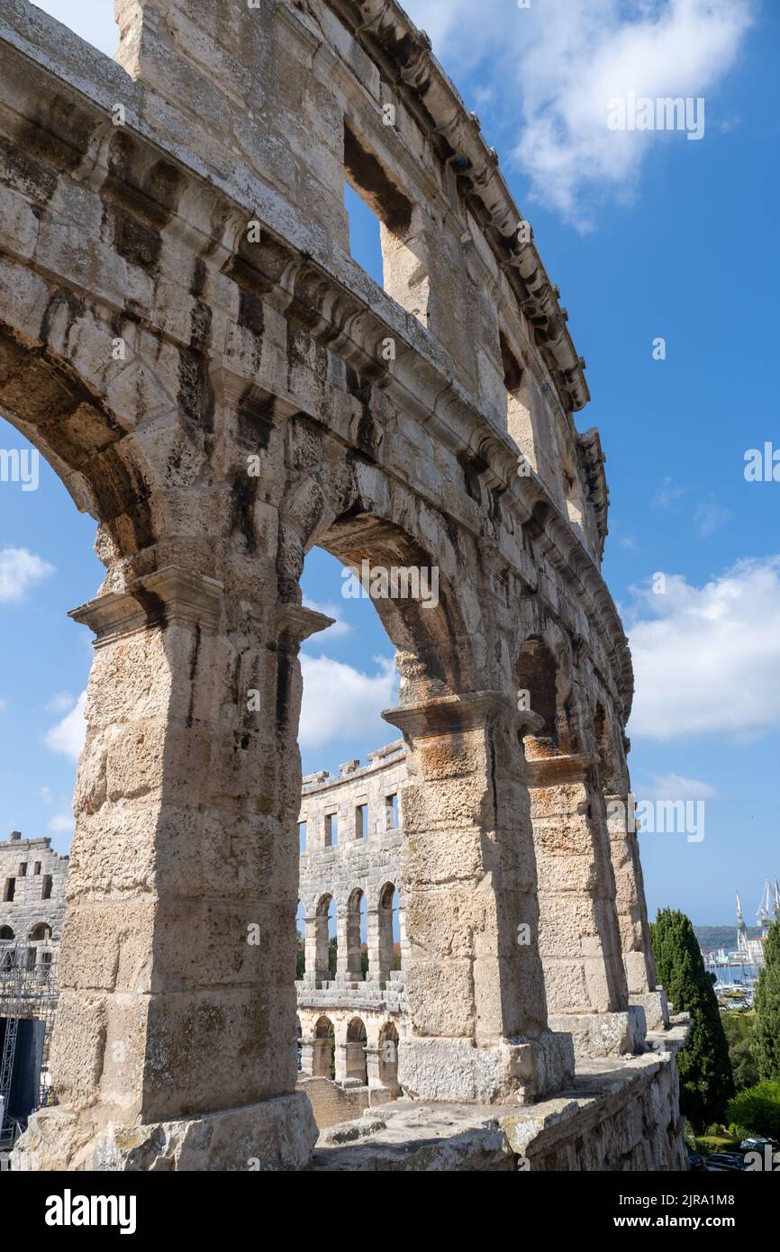 A vertical shot of a historic arch Roman arena in the city center, Pula ...