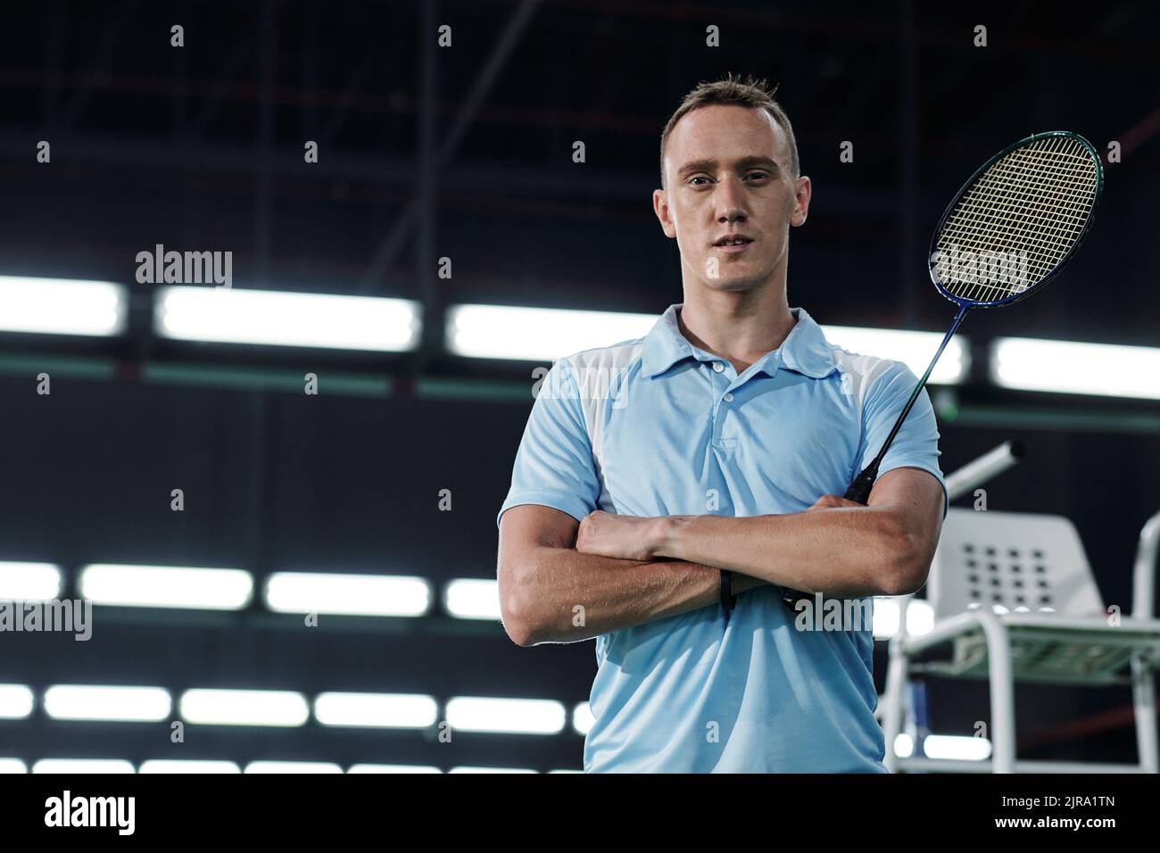 Portrait of serious young badminton player with badminton racket ...