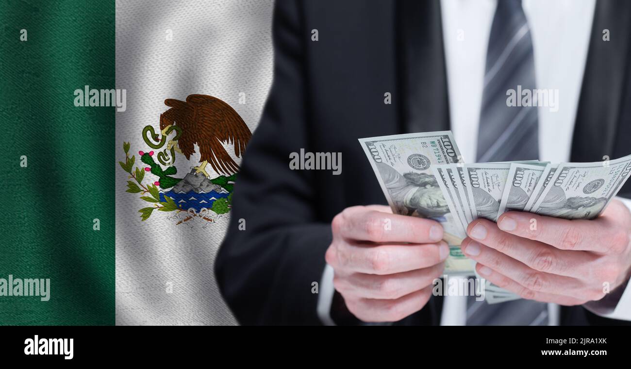 Hands holding dollar money on flag of Mexico Stock Photo - Alamy