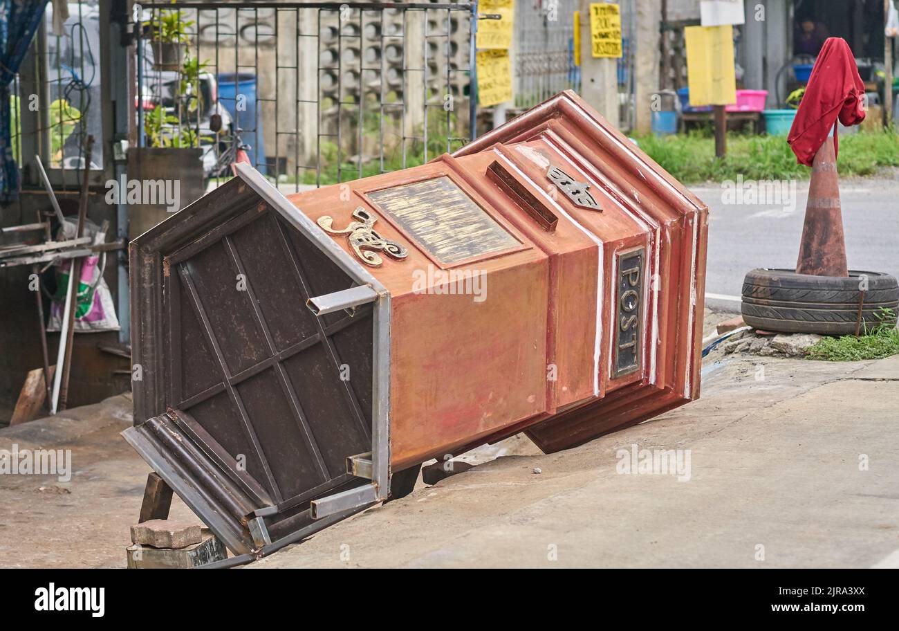 A large post office collection box toppled over on a street, in ...