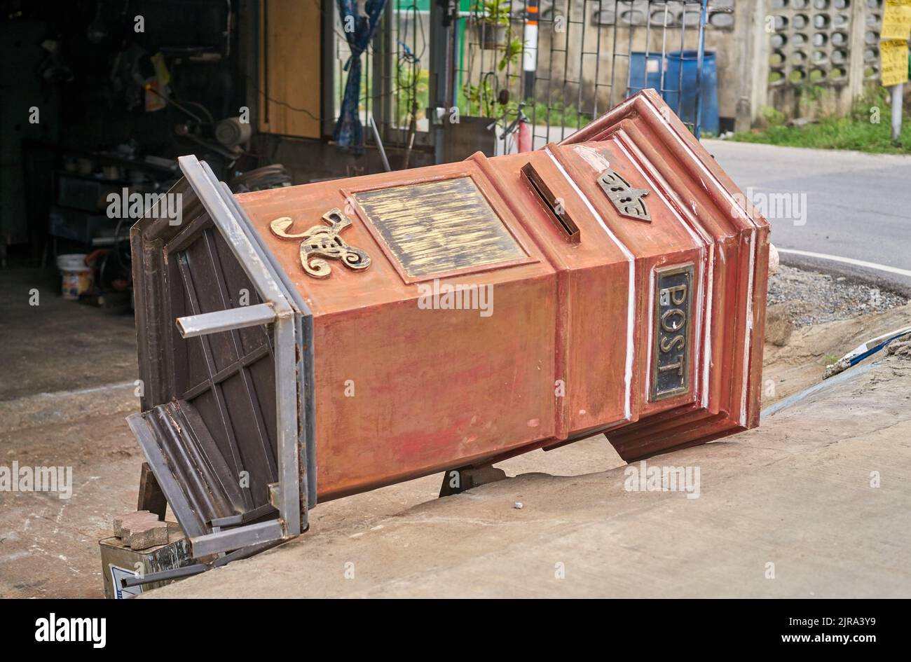 A large post office collection box toppled over on a street, in ...