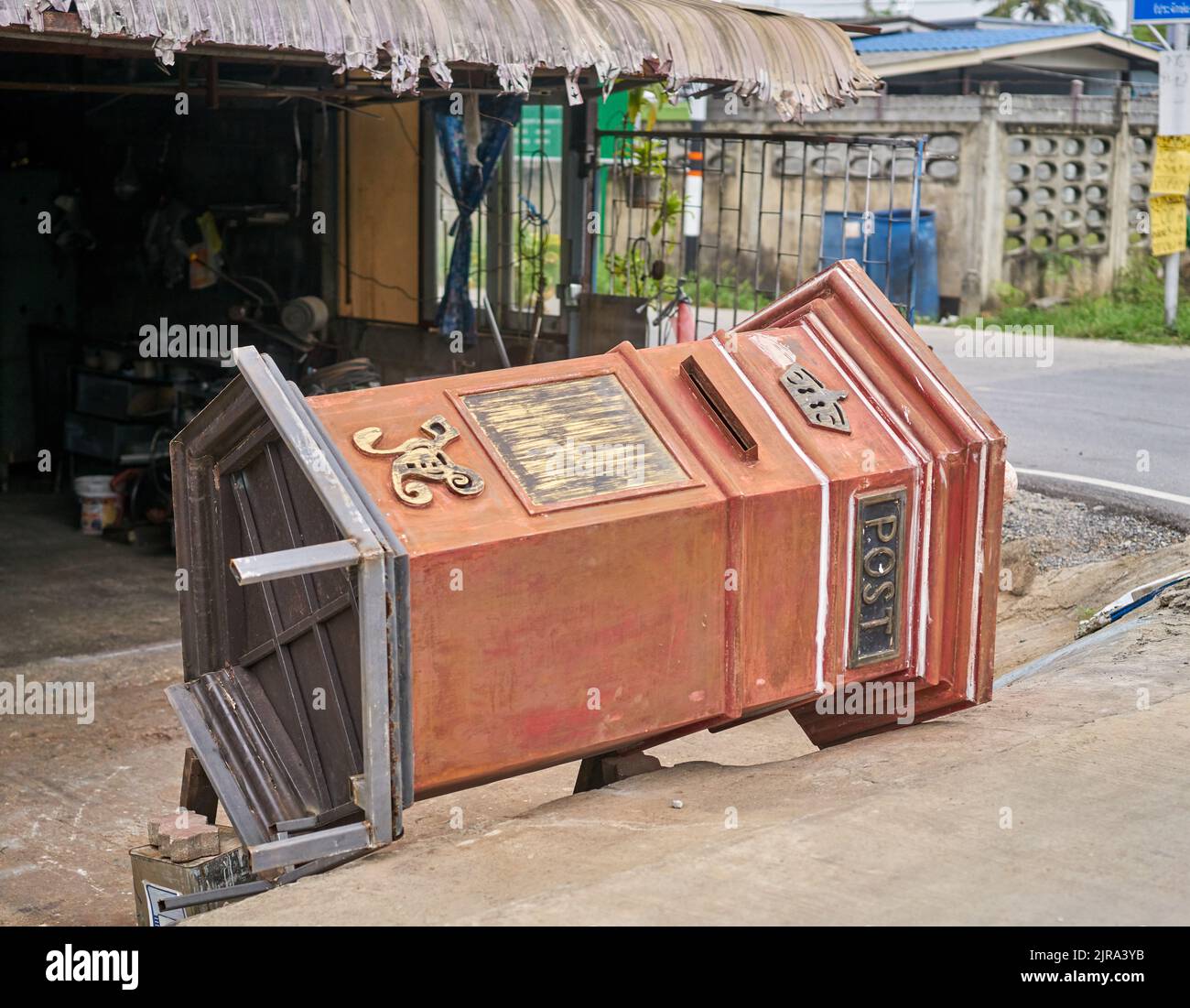 A large post office collection box toppled over on a street, in ...