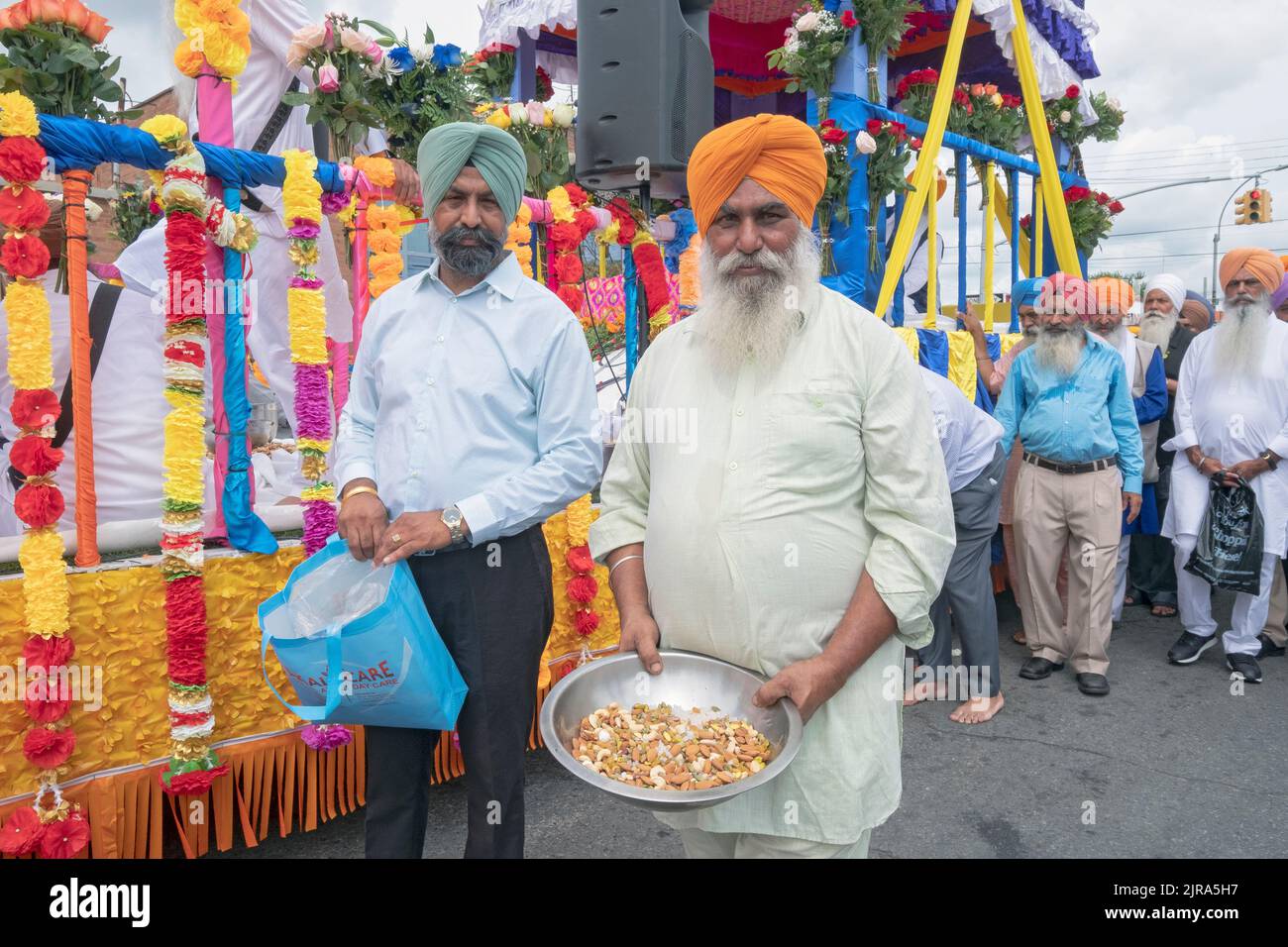 During the Sikh Nagar Kirtan parade a marcher offers nuts to onlookers ...