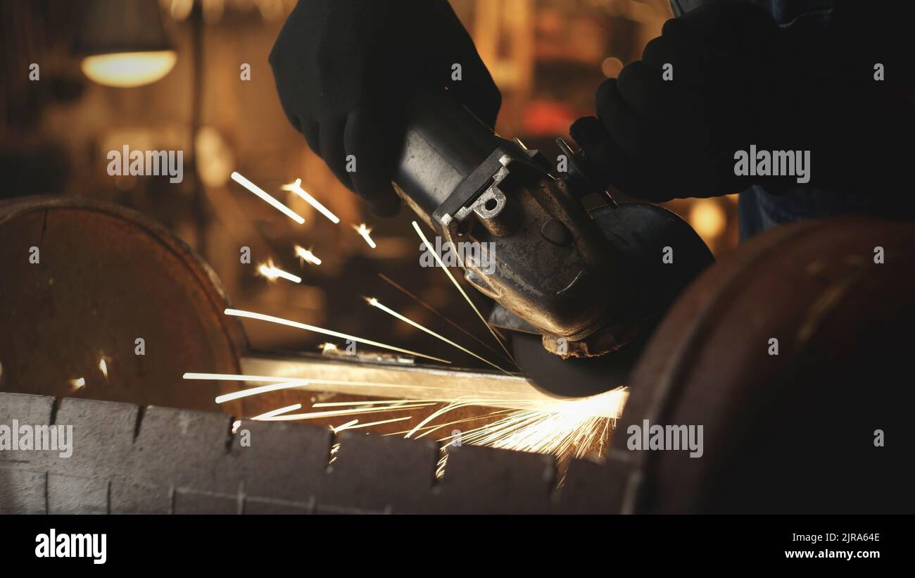 Man starting to grinding and metal processing making barbecue grill ...