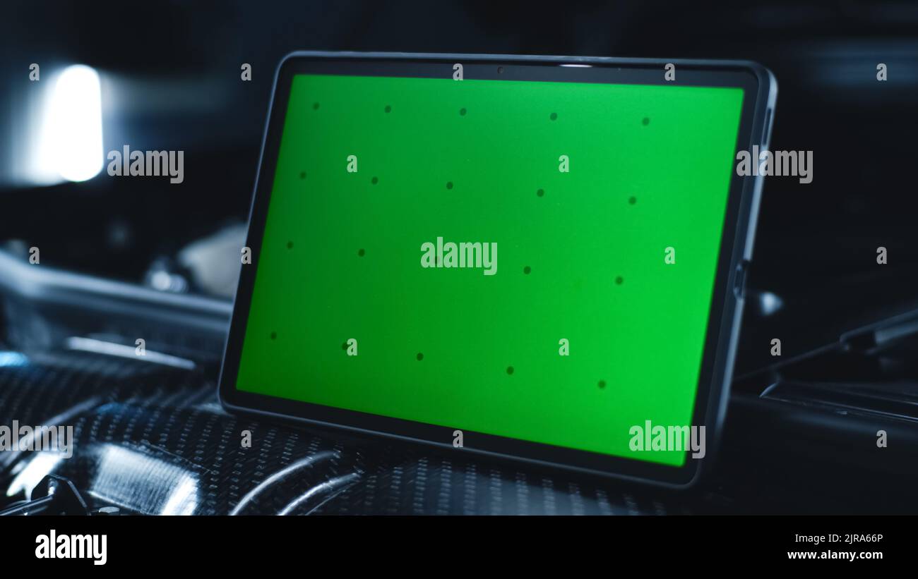 Modern tablet computer with chromakey green screen on the opened bonnet ...