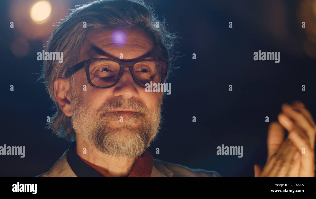 Happy director in glasses and suit smiling and applauding to actors ...