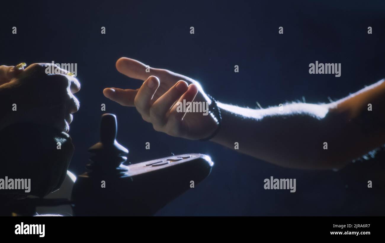 An actor on a dim stage giving a hand to an actress who use electric ...