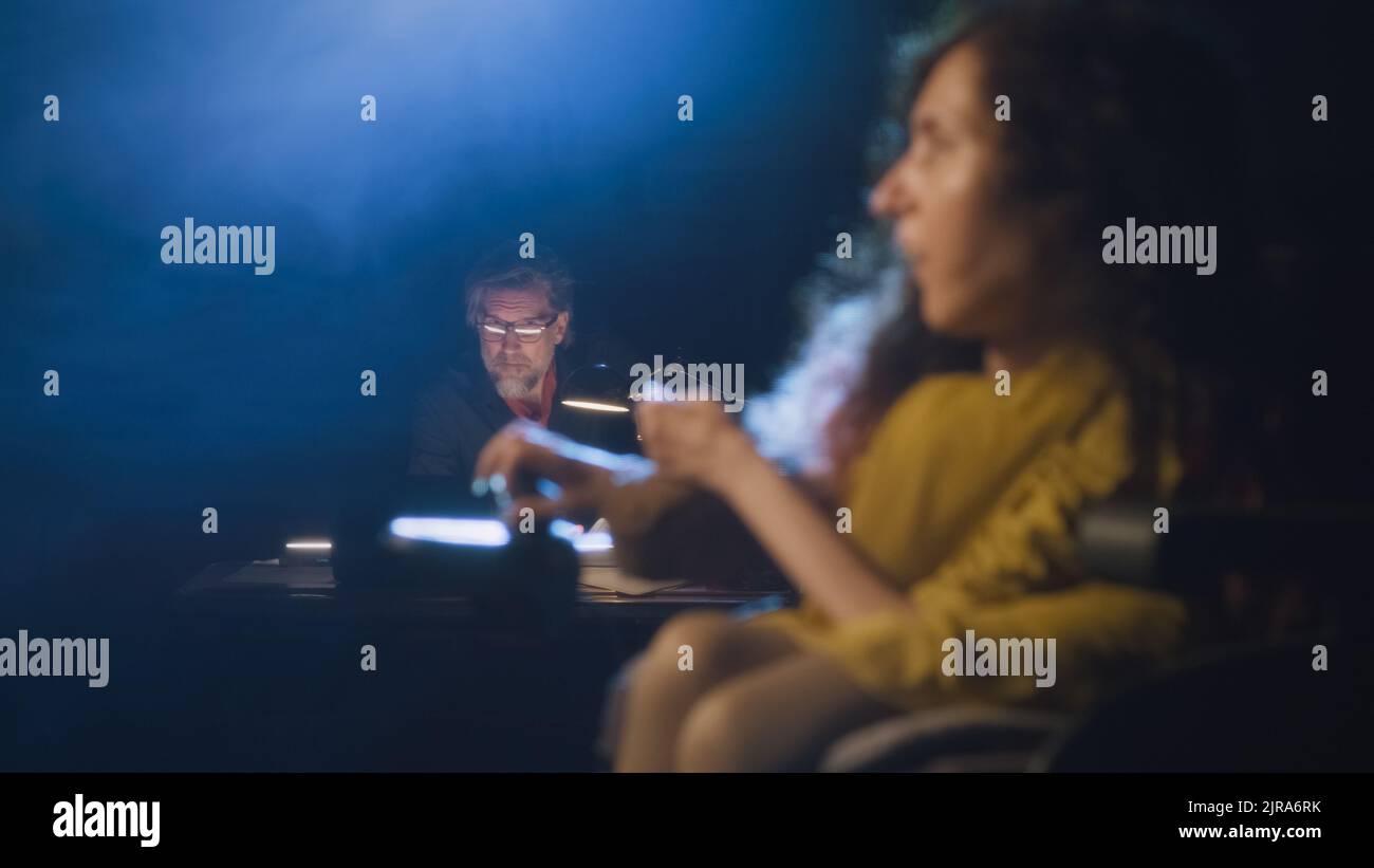 A disabled actress in a wheelchair rehearsing a scene on the dim stage ...