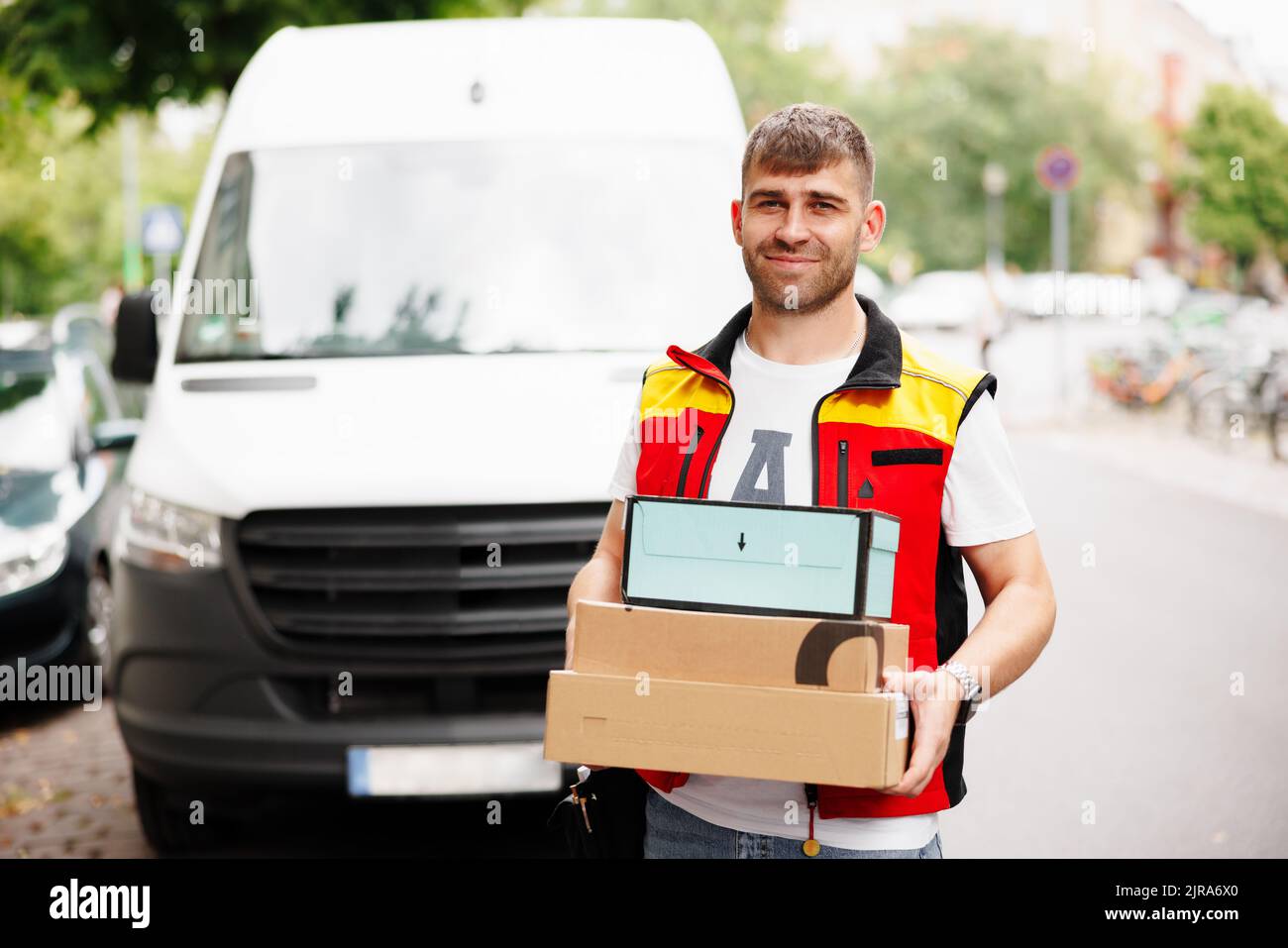 Deliveries are right on schedule. Portrait of a smiling delivery man ...