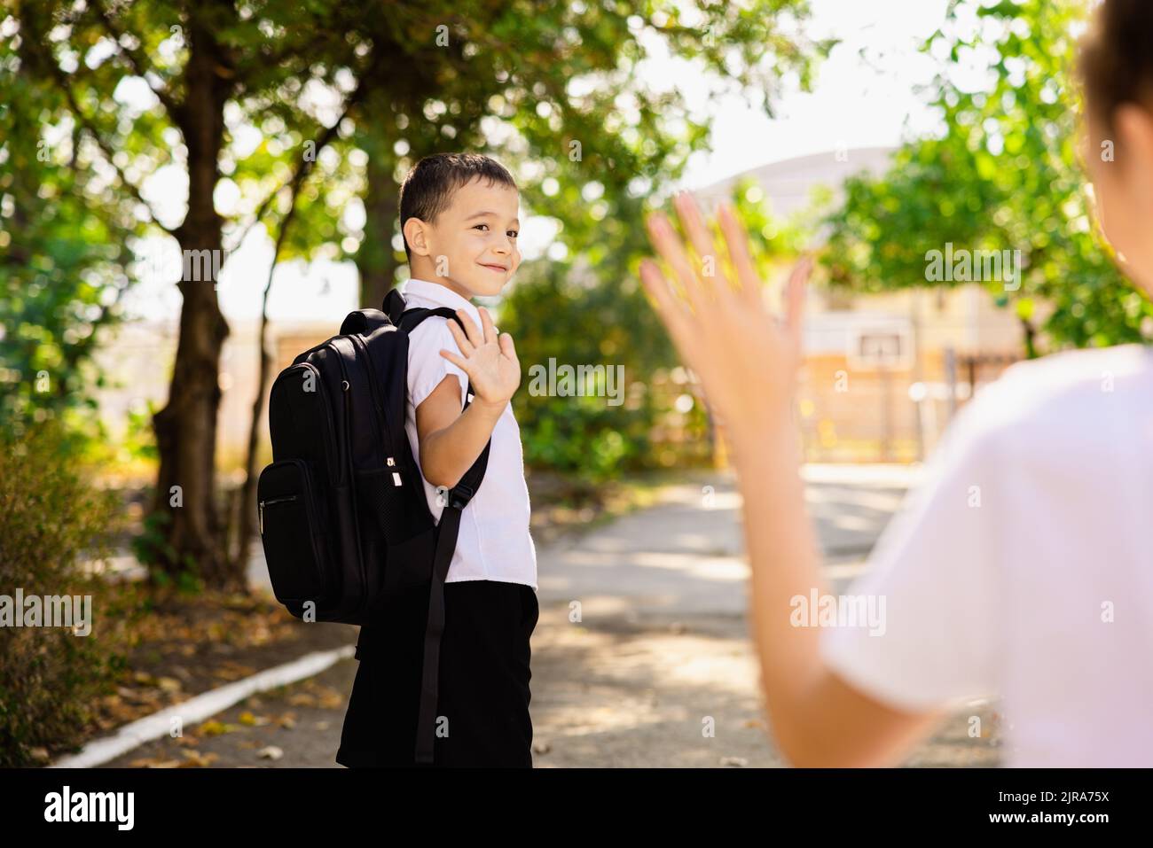 A cute boy says goodbye to his mother on the first day of school Stock ...