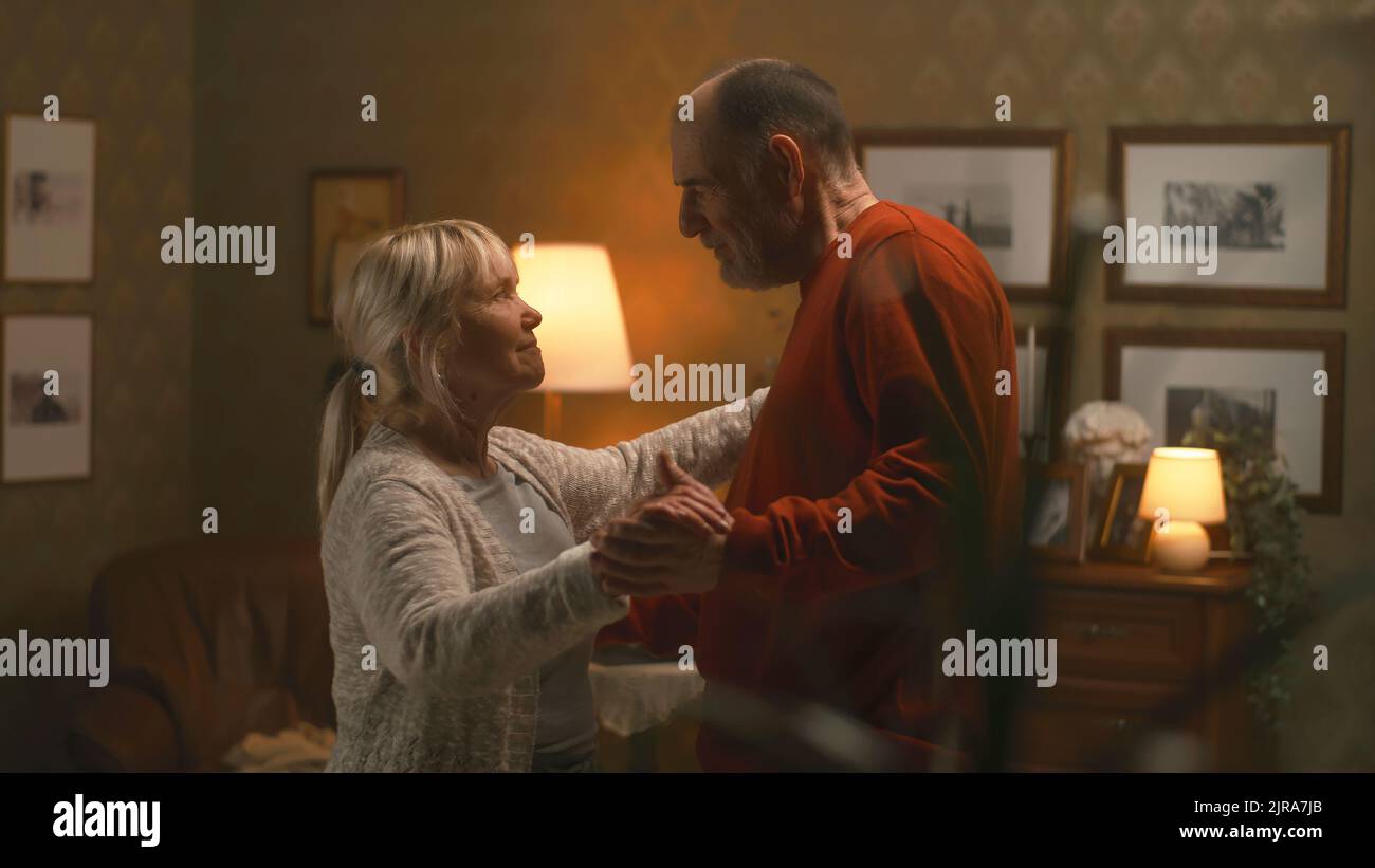 Aged spouses in love talking and dancing a romantic slow dance in the ...