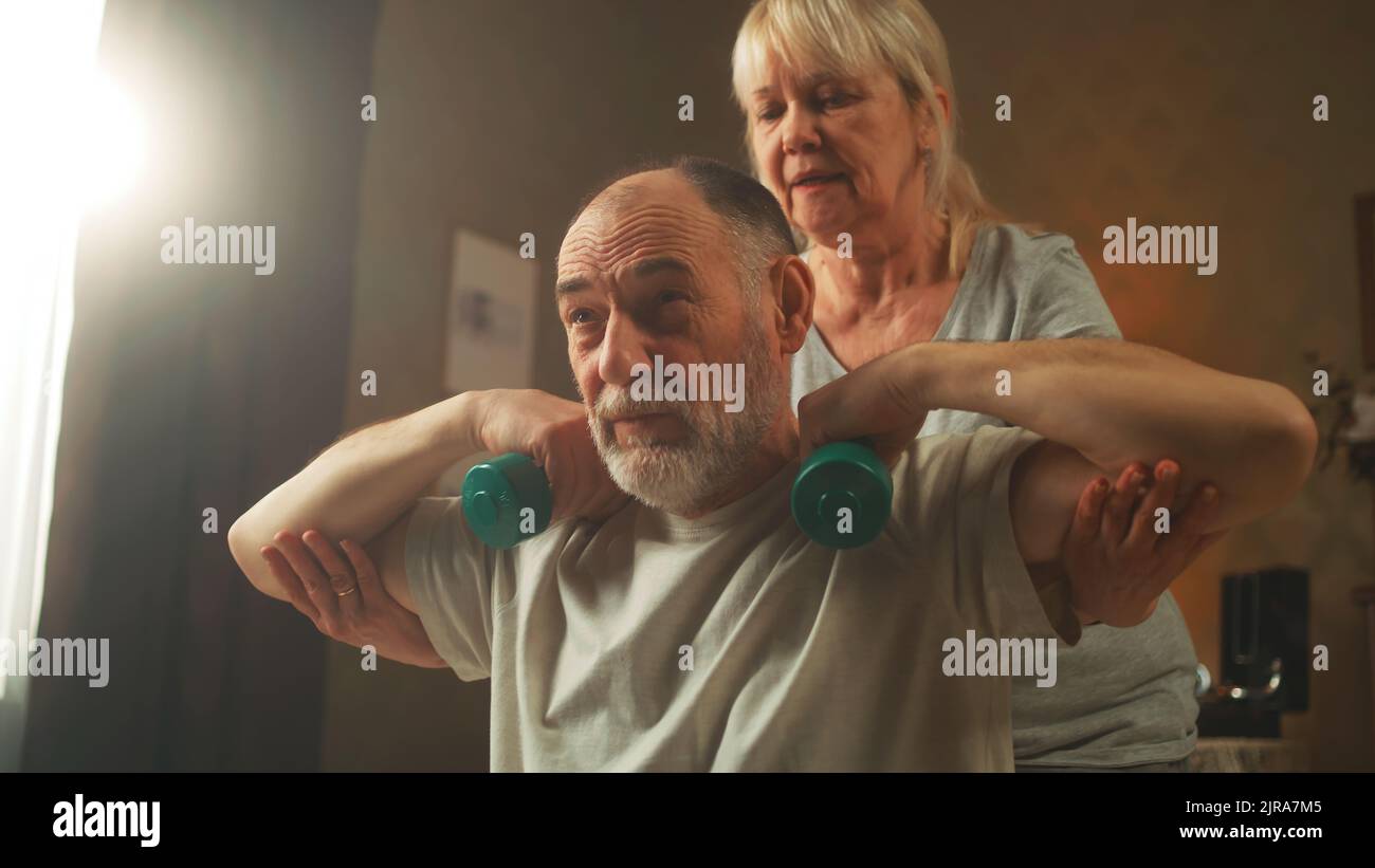 Active retired couple working out at home together and aged woman ...