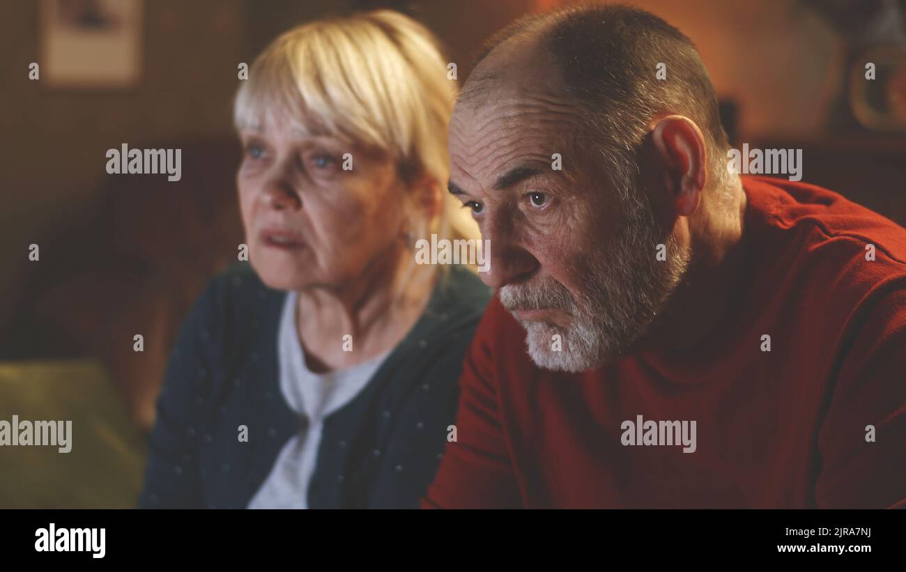 Bearded senior man listening to upset woman while sitting on sofa and ...