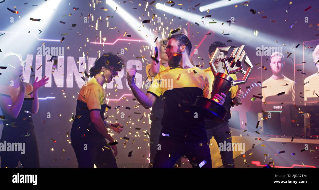 Bearded leader of cybersport team kissing golden trophy and dancing ...