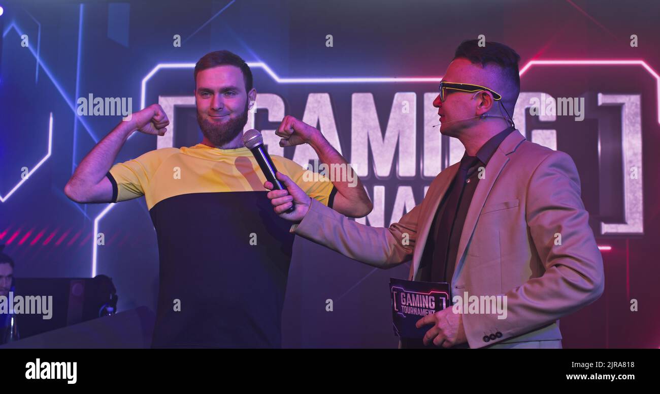 Adult man host with microphone asking questions to bearded gamer ...