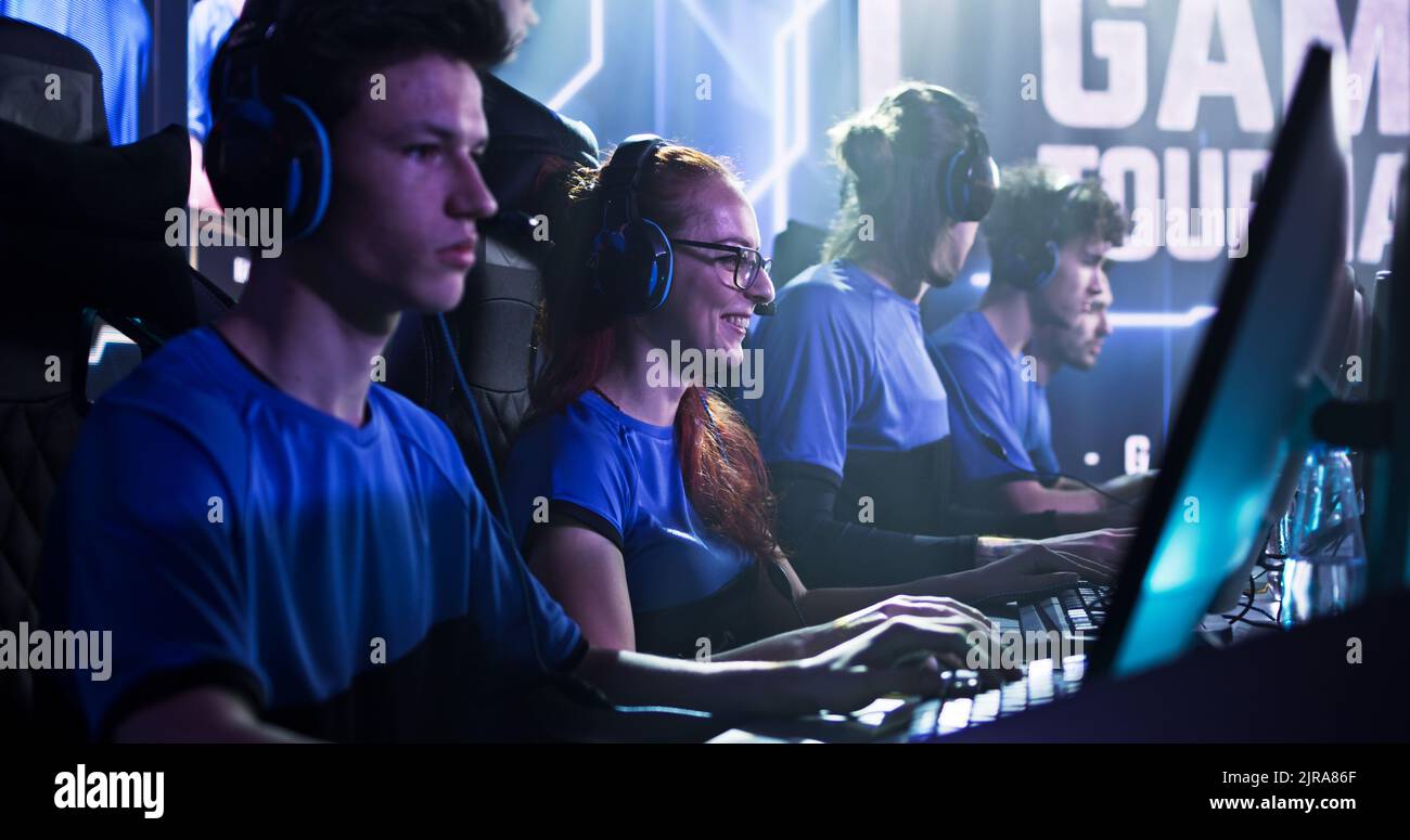 Happy esportsman gamer woman talking with male teammates then putting ...