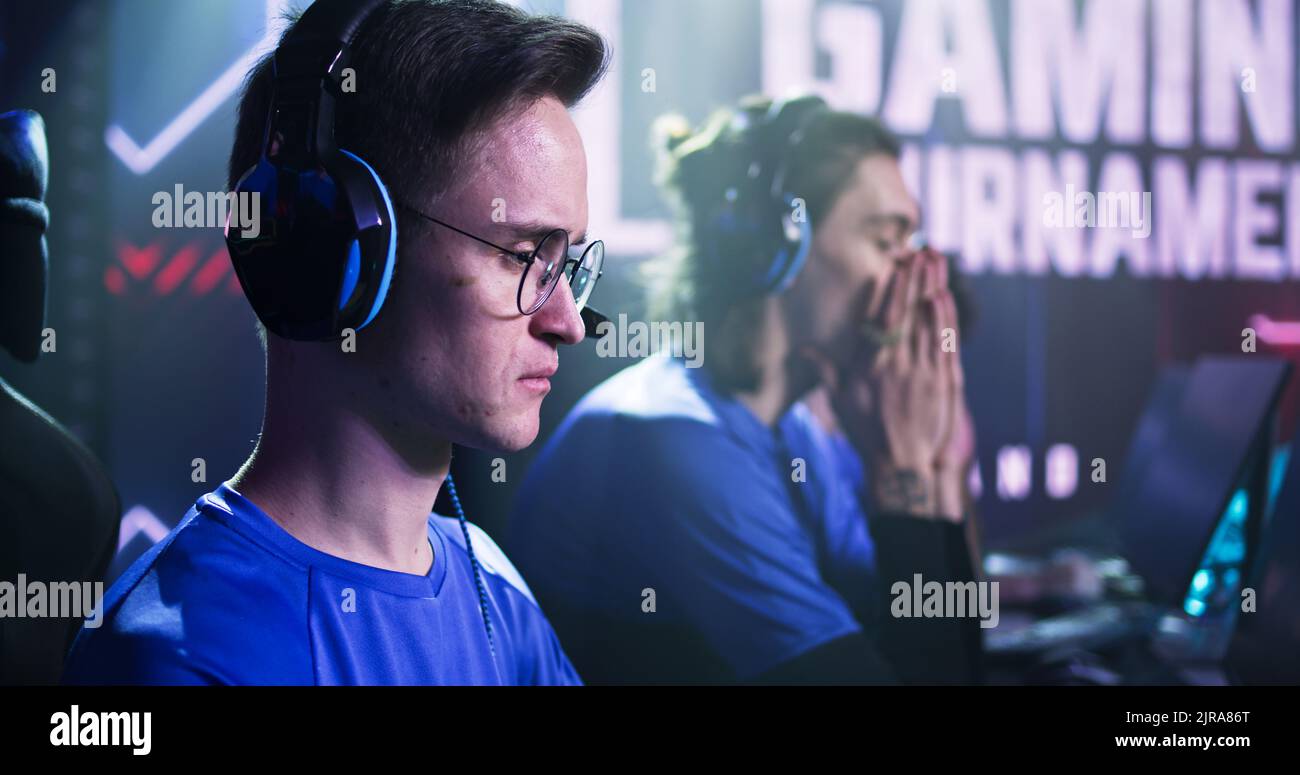 Esportsman gamer in glasses putting on headphones and bumping fists ...