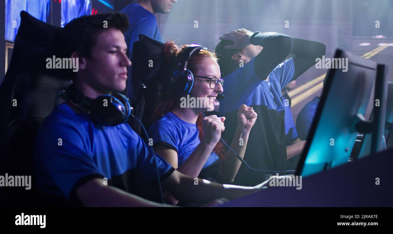 Cheerful young woman gamer esportsman in glasses and headphones smiling ...
