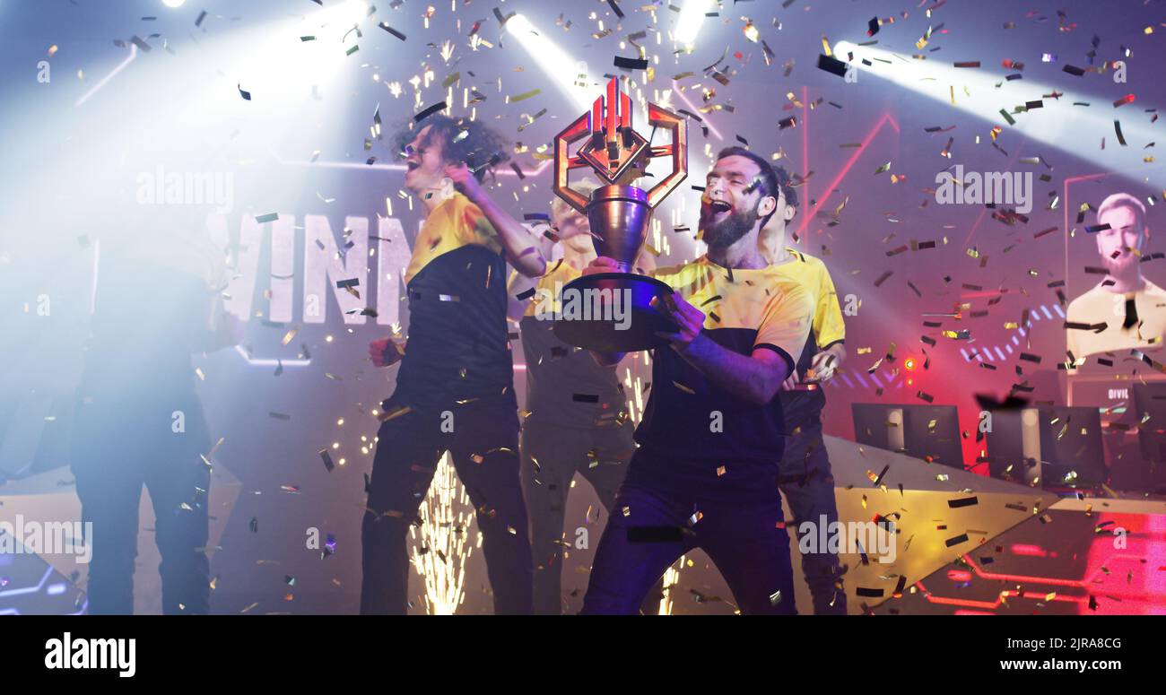 Bearded leader of cybersport team kissing golden trophy and dancing ...