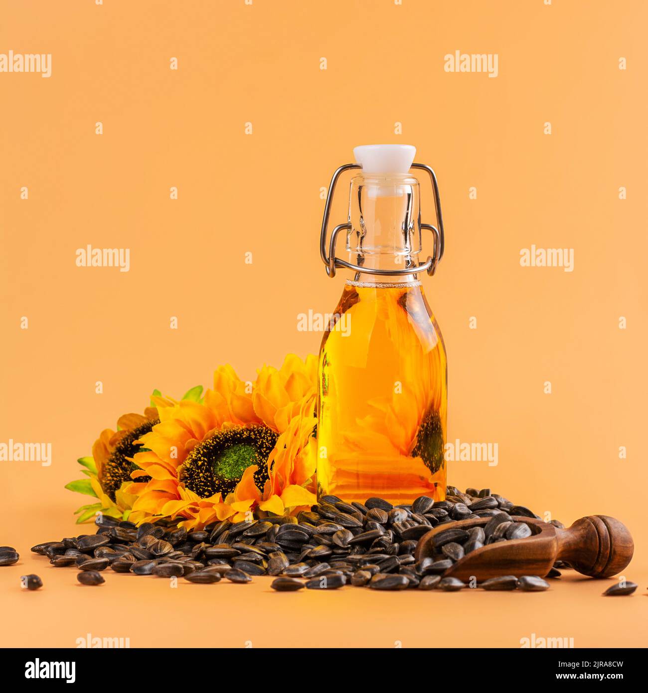 Golden unrefined sunflower oil, sunflower seeds and flowers on summer ...