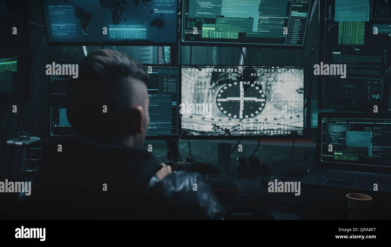 A young hacker at a table with a computer, hacking into the docking of the space module to the ...